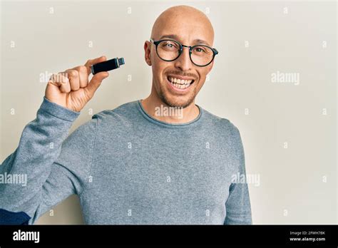 Bald Man With Beard Holding Removable Memory Usb Looking Positive And