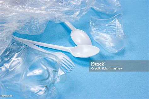 플라스틱 숟가락 포크 및 컵은 밝은 파란색 배경에 복사 공간이있는 일회용 폐기물로 환경 오염 및 쓰레기 재활용 개념 0명에 대한