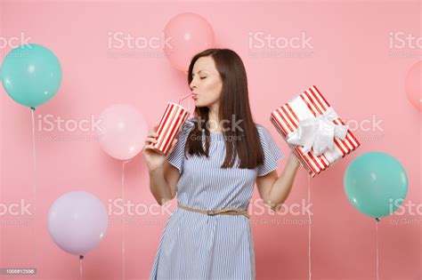파란 드레스에 닫힌된 눈으로 아름 다운 여자의 초상화 선물 현재 화려한 공기 풍선 핑크 배경에 플라스틱 컵에서 소 다 또는