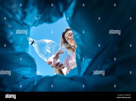 A Woman Throws A Plastic Bottle Into The Trash Close Up From Inside