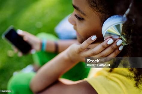 풀밭에 앉아서 헤드폰 고각보기로 음악을 즐기는 다인종 소녀 꿈꾸기에 대한 스톡 사진 및 기타 이미지 꿈꾸기 낮 듣기 Istock