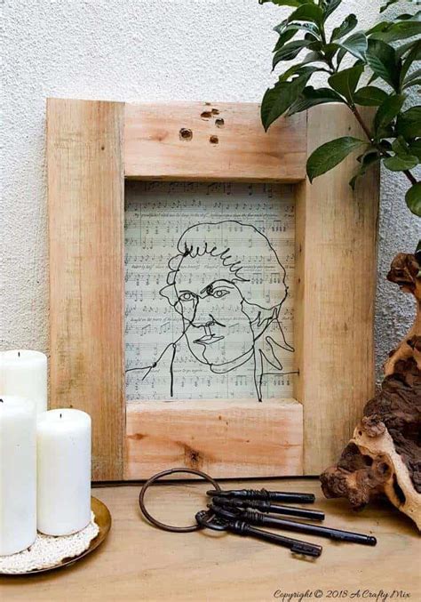 A Wooden Frame Sitting On Top Of A Table Next To Candles And A Potted Plant