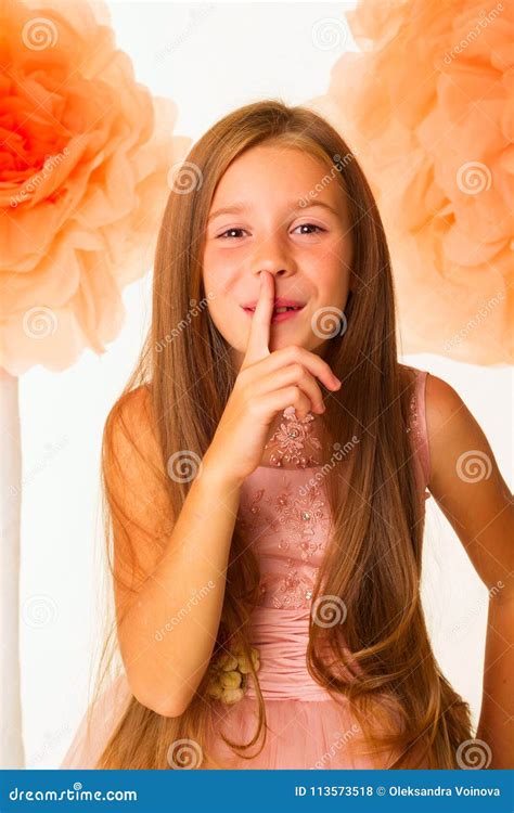 Portrait Of Little Pretty Girl Showing Silence Gesture Over Flow Stock