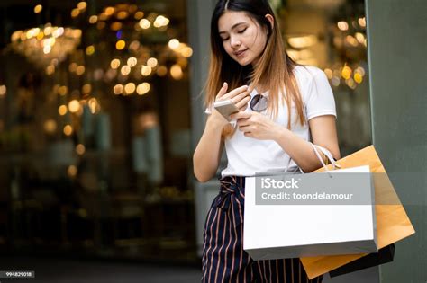 아름 다운 여자 긴 머리 그녀는 행복 하 게 거리 쇼핑몰에서 쇼핑 그녀의 종이 휴대 전화 빛 Bokeh 복사 공간 사진 여러