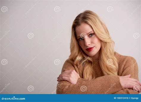 Attractive Young Woman With Blond Hair And Red Lipstick Sitting At