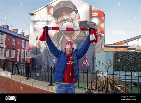 A Fan Poses For A Photo By A Mural Of Liverpool Manager Jurgen Klopp On
