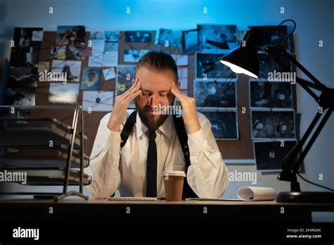Detective Working At Desk In His Office Thinking On Problem Evidence