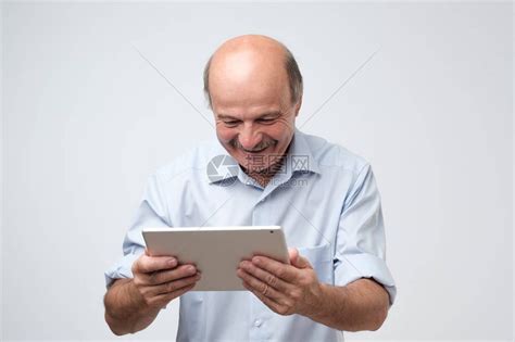 快乐成熟的欧洲男人在数字平板电脑上工作高清图片下载 正版图片505393220 摄图网