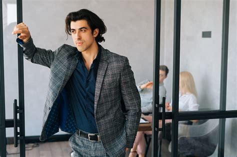 현대 사무실에 서서 카메라를 보고 있는 양복을 입은 성공적인 사업가의 초상화 프로젝트를 논의하는 스타트업 사업팀 25 29세에