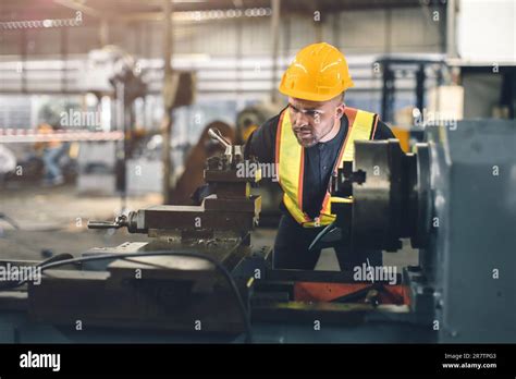 Young Engineer Male Worker Work In Heavy Metal Industry Cnc Lathe