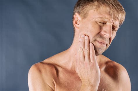 그의 뺨을 잡고 고통에 슬픈 우울한 남자입니다 파란색 배경에 남자의 초상화입니다 감정 얼굴 식입니다 감정과 사람들 반응입니다 치 통 개념에 대한 스톡 사진 및 기타 이미지