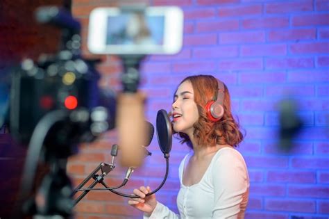 Premium Photo A Young Smiling Female Singer Wearing Headphones With A