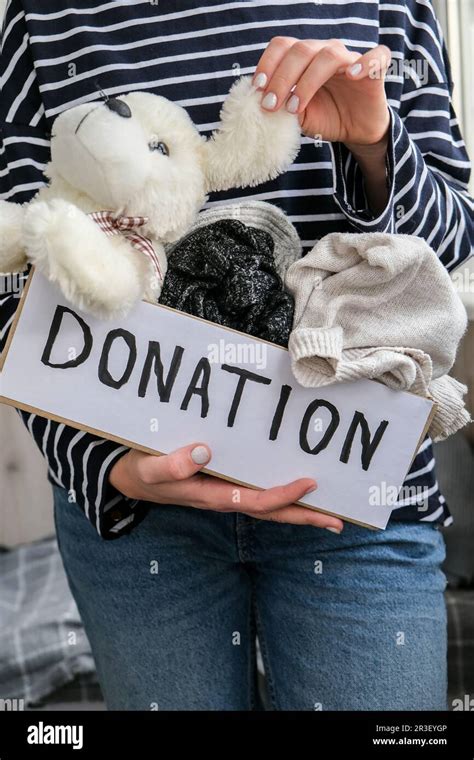Female Volunteer Holding Donation Box With Old Used Toys And Clothes