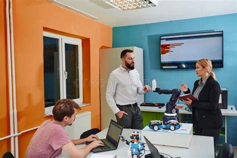 A Group Of Colleagues Working Together In A Robotics Laboratory