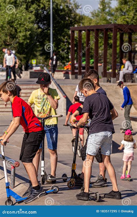 Group of Different Age Boys Riding a Scooter at a Skatepark. Active ...