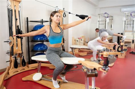 Sports Club Girl Client On Reformer With Cable And Rope Performs