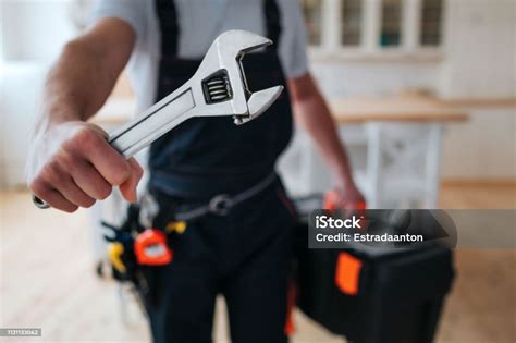 카메라에 가까운 손에 도구 상자와 렌치를 들고 핸디의 절단 보기 그는 부엌에 서 있다 남자는 특별 한 유니폼을 착용 합니다 일광 작업 장비에 대한 스톡 사진 및 기타 이미지