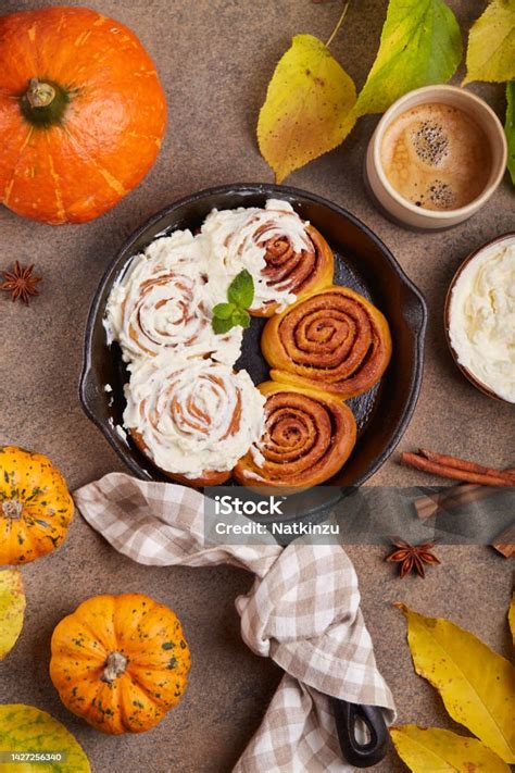 호박 계피 롤 효모 반죽 빵은 설탕과 계피 채우기와 크림 치즈 프로스팅으로 나선형 모양으로 만두를 만듭니다 위쪽 보기 0명에