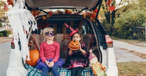 트릭 또는 트렁크 어린이 형제 자매는 차 트렁크에서 할로윈을 축하합니다 10 월 휴일 야외를 준비하는 친구 어린이 소녀 사회적 거리와 안전한 대안 축하 사진