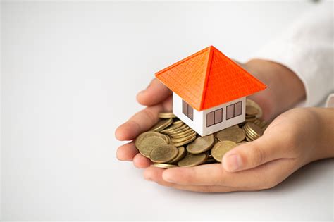 동전과 주택 모델 주택 산업 모기지 계획 및 주거 세금 저축 전략 모기지 투자 부동산 및 부동산 개념을 들고 손 저축에 대한