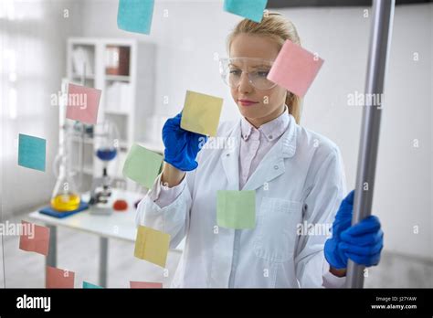 Woman Scientist In Laboratory Write Chemical Formula On Sticky Notes