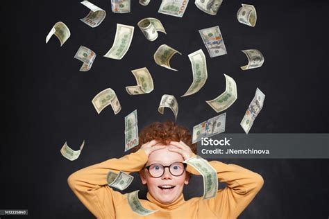 재미 놀란 빨간 머리 작은 아이 소년 우리와 함께 안경에 우리 달러 돈 비가 검은 배경에 10 11세에 대한 스톡 사진 및 기타