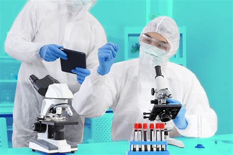 혈액 샘플 테스트결과를 확인하면서 실험실에서 일하는 Ppe 소송에서 두 명의 남성 과학자 블루 톤 2명에 대한 스톡 사진 및