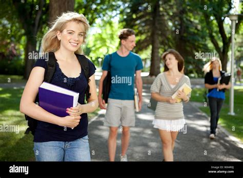 Pretty Blond College Girl Looking At Camera With Friends In Background
