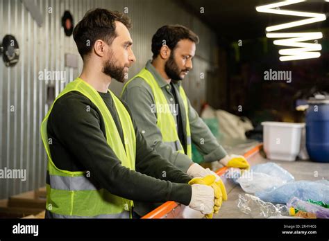 Side View Of Male Sorter In High Visibility Vest And Gloves Standing