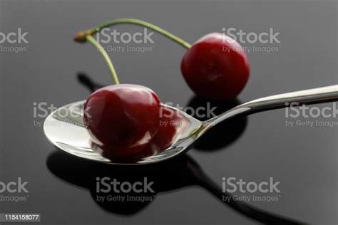 나뭇가지에 달콤한 체리의 두 익은 열매는 어두운 광택 배경에 숟가락에 거짓말 0명에 대한 스톡 사진 및 기타 이미지 0명 건강한 식생활 검은색 Istock