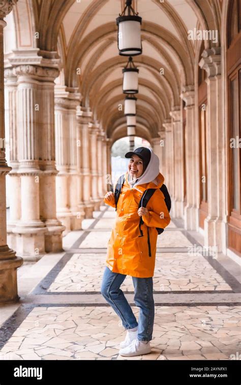 Woman Tourist Walking With Backpack In Yellow Raincoat City Tourism