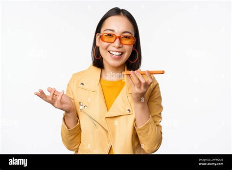 Image Of Happy Asian Girl Talking On Speakerphone Recording