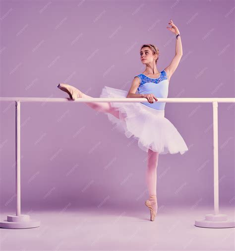Bailarina Clásica Posando En La Barra De Ballet Foto Gratis