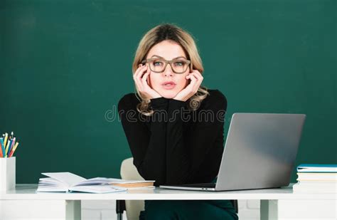 Portrait Of Teacher At School With Computer Laptop In Classroom On