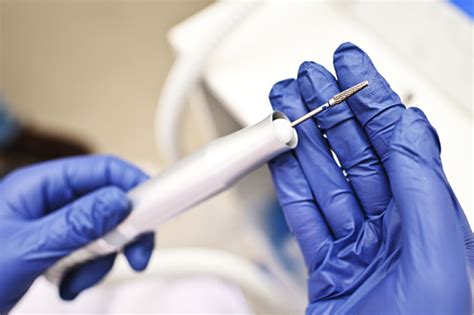 페디큐어 드릴이있는 장치와 손발톱 진균증 치료를위한 파일을 들고있는 고무 장갑을 낀 Podologist의 클로즈업 곰팡이 손톱 질환 족부전문의에 대한 스톡 사진 및 기타