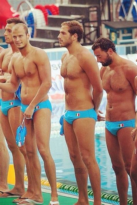 Six Men In Blue Swimsuits Standing On The Edge Of A Swimming Pool With