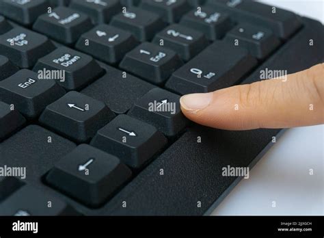 A Woman S Finger Holding A Computer Keyboard Stock Photo Alamy