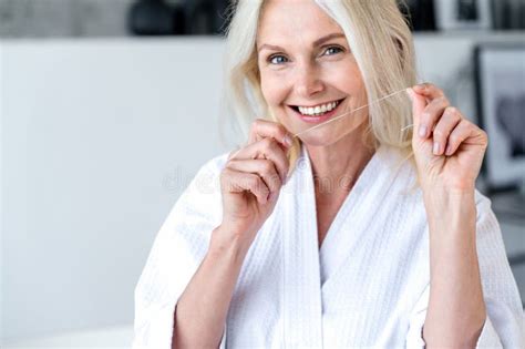 Mature Woman With Perfect White Smile Using Teeth Thread Stock Image