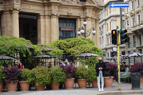 낮 동안 갈색 콘크리트 바닥에 서 있는 흑백 꽃 드레스를 입은 여자 사진 Unsplash의 무료 이탈리아 이미지