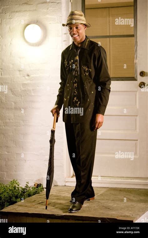 Cheerful Young Man Standing In Front Of The Door And Holding An