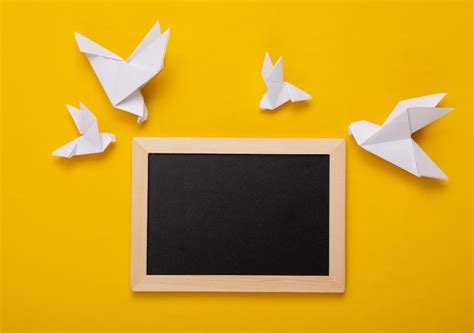 Mini Pizarra Y Palomas De Origami Sobre Fondo Amarillo Pizarra En Blanco Vacía Con Espacio De