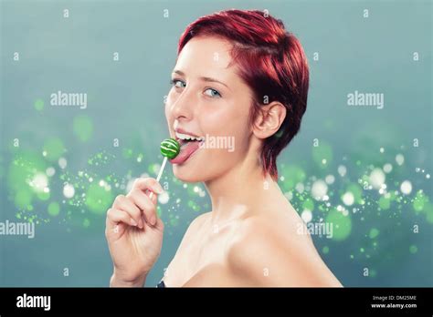 Redhead Woman Licking A Green Lollipop Stock Photo Alamy