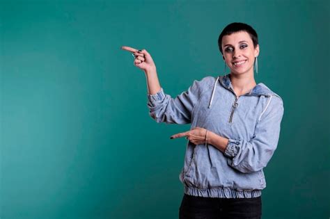 Улыбающаяся брюнетка с короткими волосами указывающая в сторону