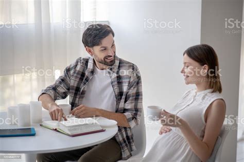 검은 머리 남자와 그의 임신 한 아내는 부엌에 앉아 있고 기분이 좋아 2명에 대한 스톡 사진 및 기타 이미지 2명 30