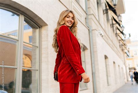 Beautiful Smiling Woman In Elegant Red Velvet Suit Holding Purse And