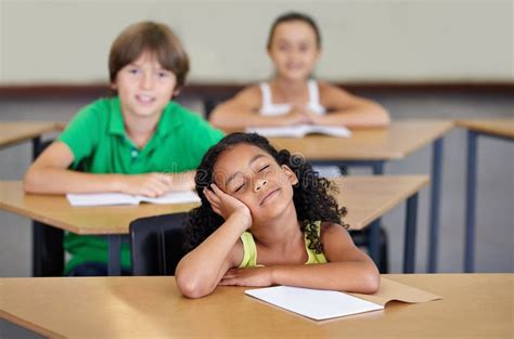 School Is Wearing Her Out A Bored Looking Ethnic Girl Sitting At Her