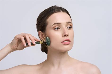 Premium Photo Young Caucasian Woman Using Cosmetic Green Jade Stone