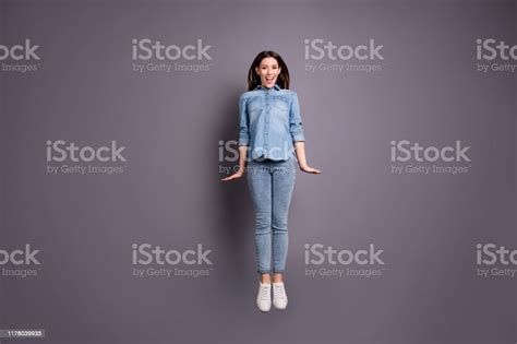 시즌 낮은 쇼핑 가격에 의해 기뻐 높은 점프 미친 여자의 전체 길이 사진은 캐주얼 청바지 의상 고립 된 회색 배경을 착용 갈색