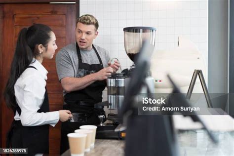 앞치마를 두르고 커피숍에서 커피 그라인더를 따르는 바리스타 카페 스팀 에스프레소 커피 머신으로 커피를 만드는 작업자 중소기업 개념 20 24세에 대한 스톡 사진 및 기타