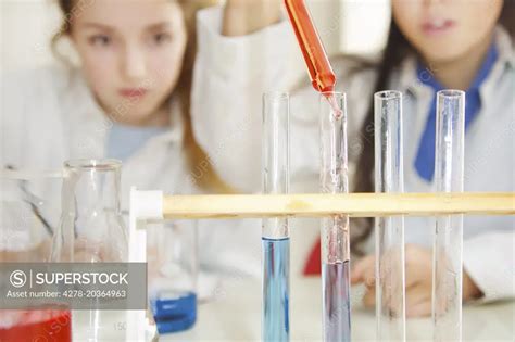 Schoolgirls Experimenting With Alkaline Acid Ph At Chemistry Class
